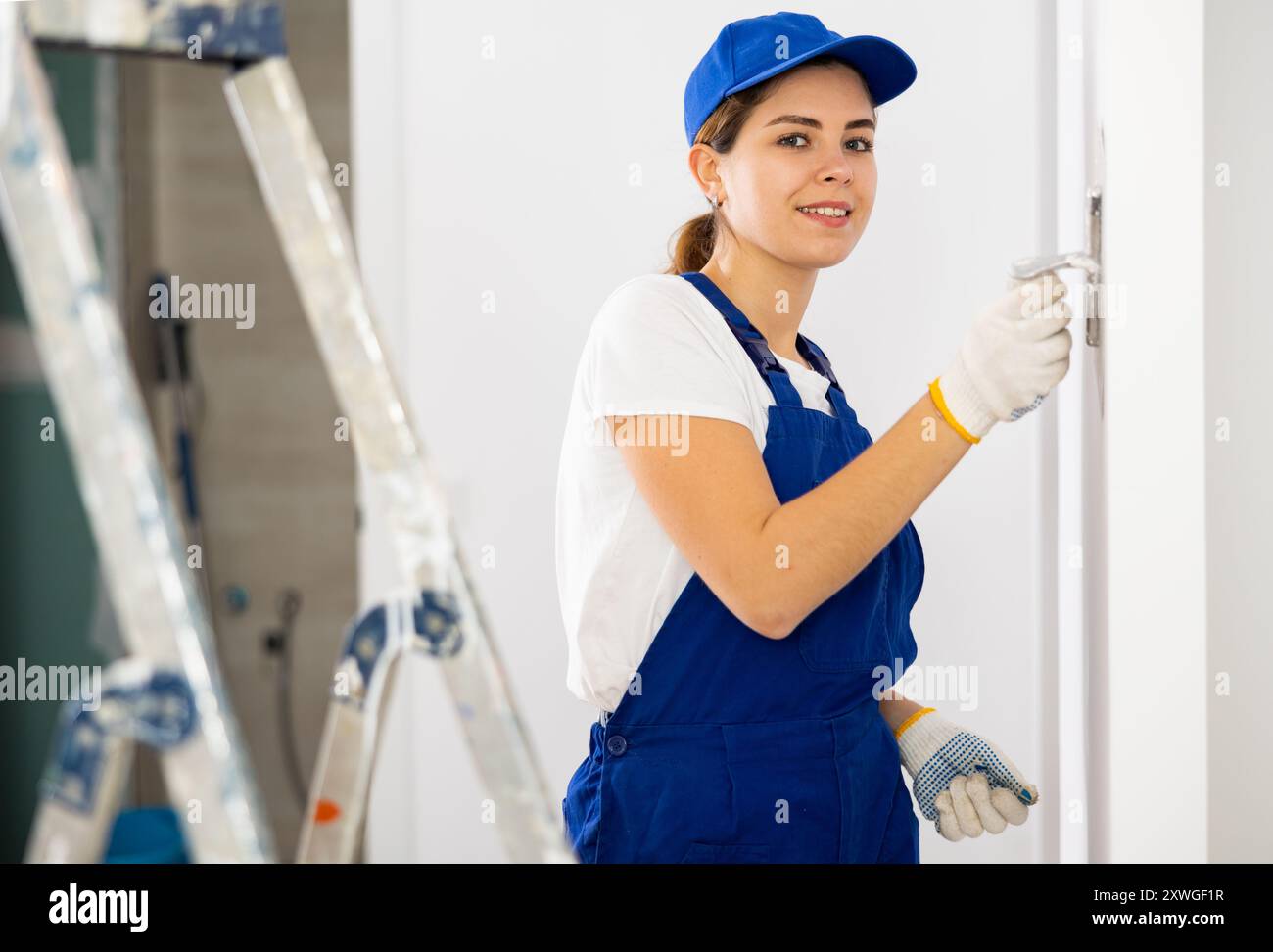 Woman builder using floated trowel to daub plaster to wall Stock Photo ...