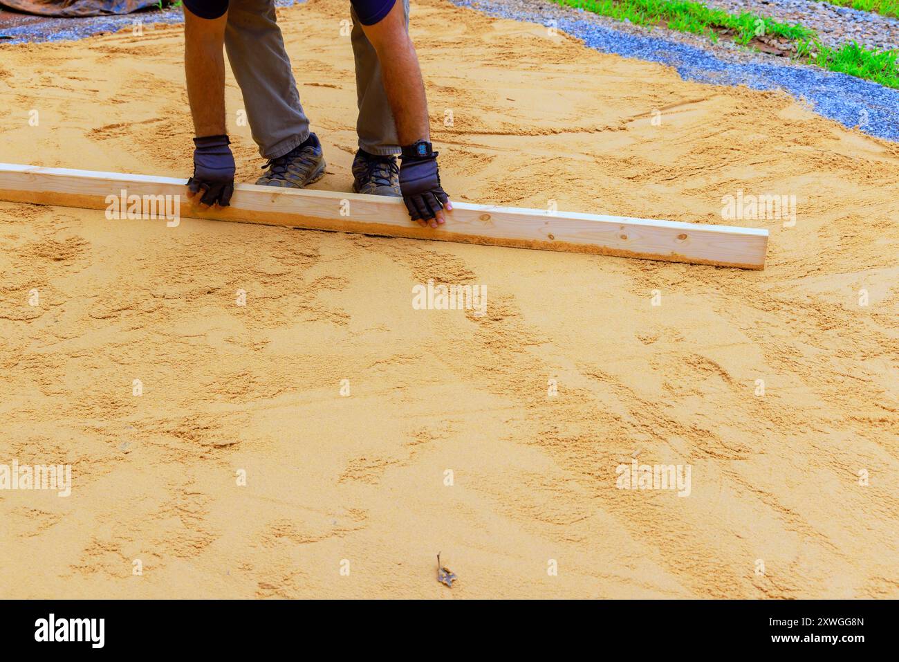 Using level for leveling sand when preparing platform for installation ...