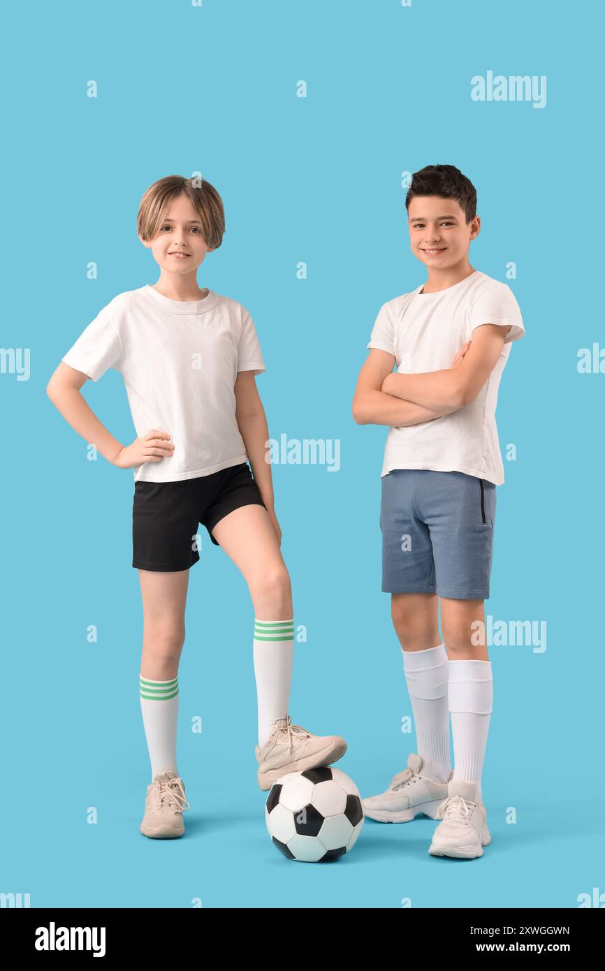 Happy brothers with soccer ball on blue background Stock Photo - Alamy