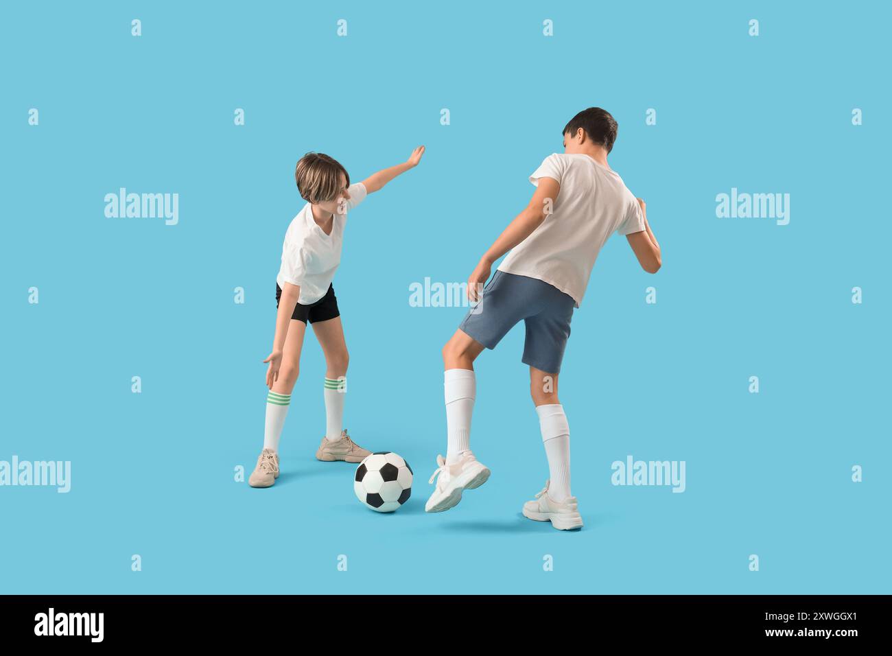 Happy brothers playing football on blue background Stock Photo - Alamy