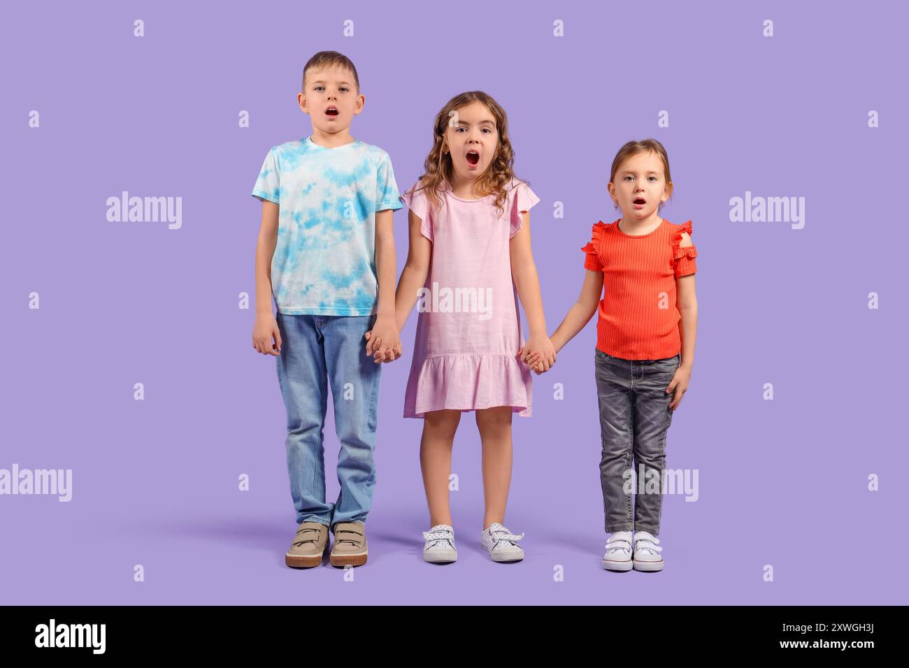 Shocked little kids on purple background Stock Photo - Alamy