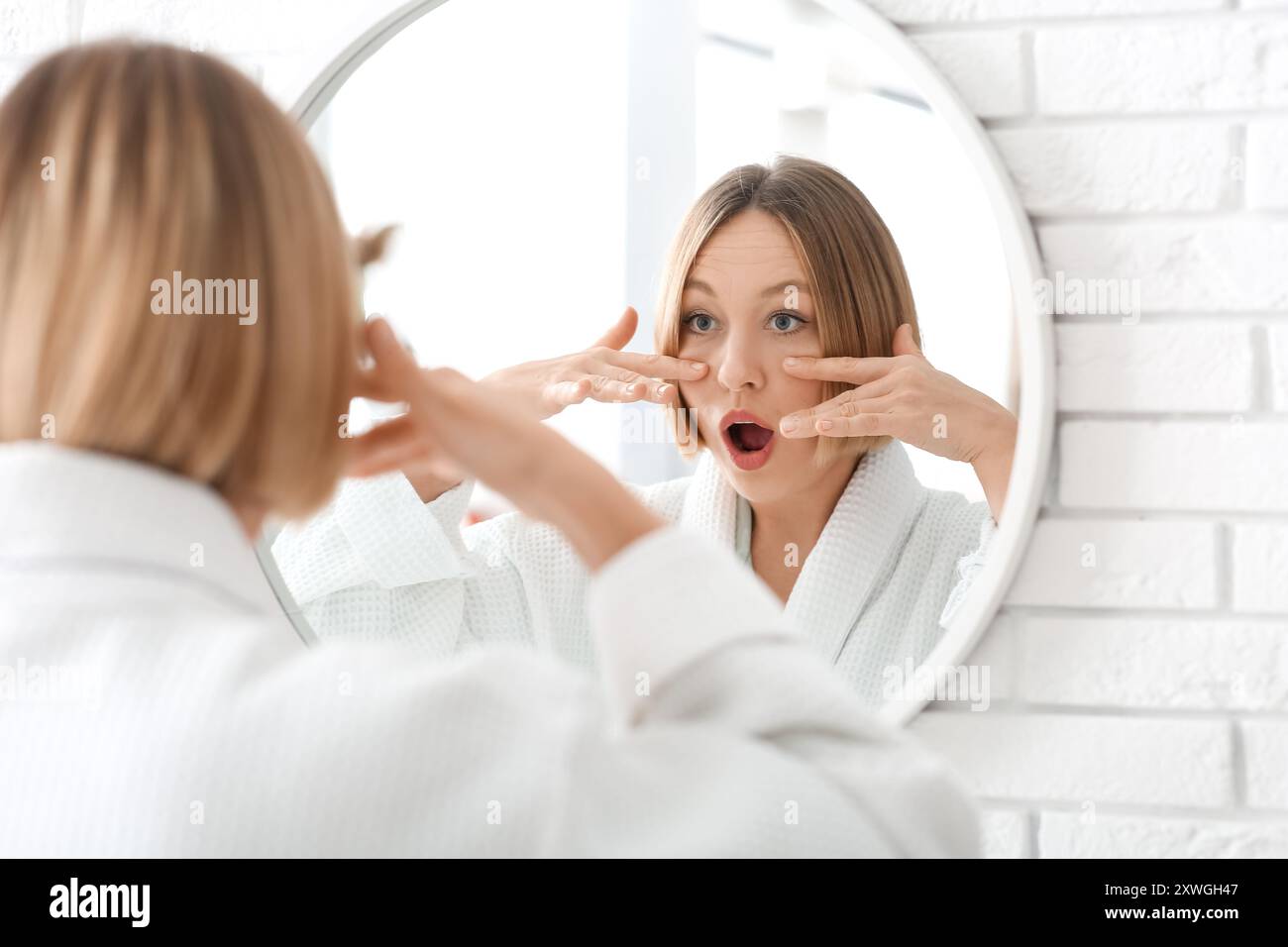 Woman doing face building exercise in bathroom Stock Photo - Alamy