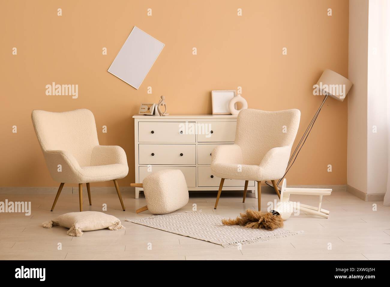 Interior of damaged living room with armchairs and chest of drawers ...