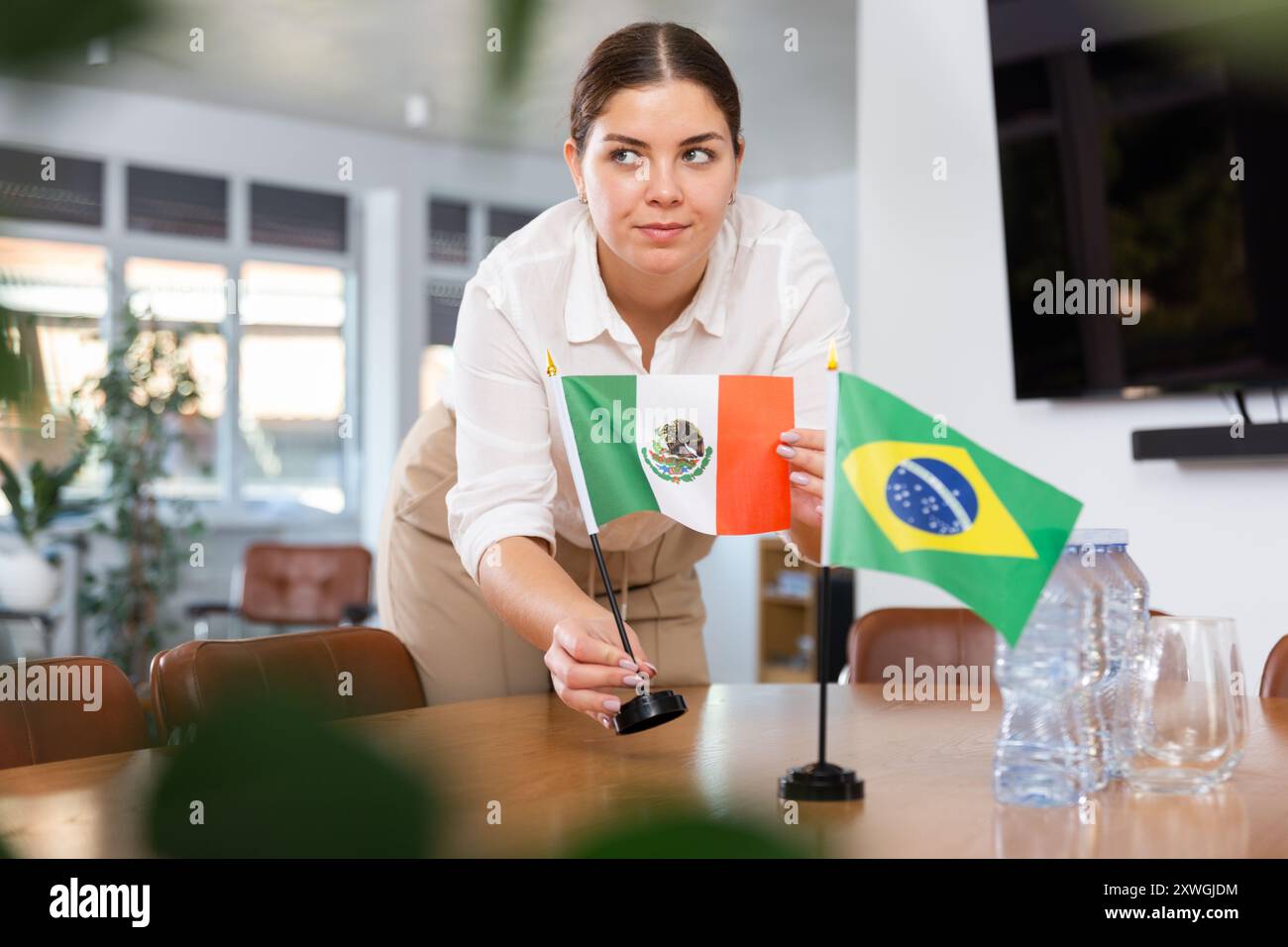 female assistant prepares conference room for diplomats of Brazil and ...