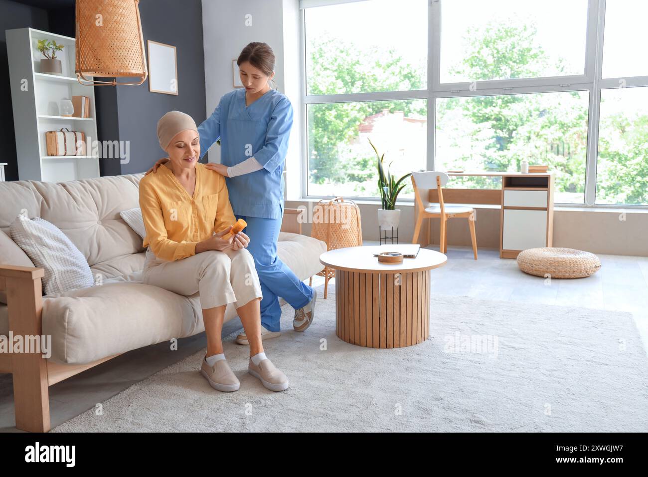 Mature woman after chemotherapy with bottle of weed and doctor at home ...