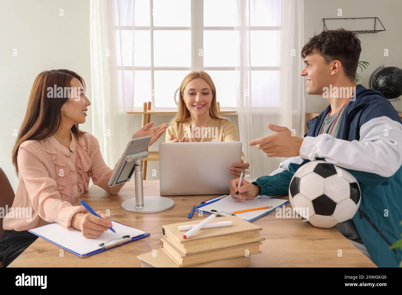 Teachers talking at table in school office Stock Photo - Alamy