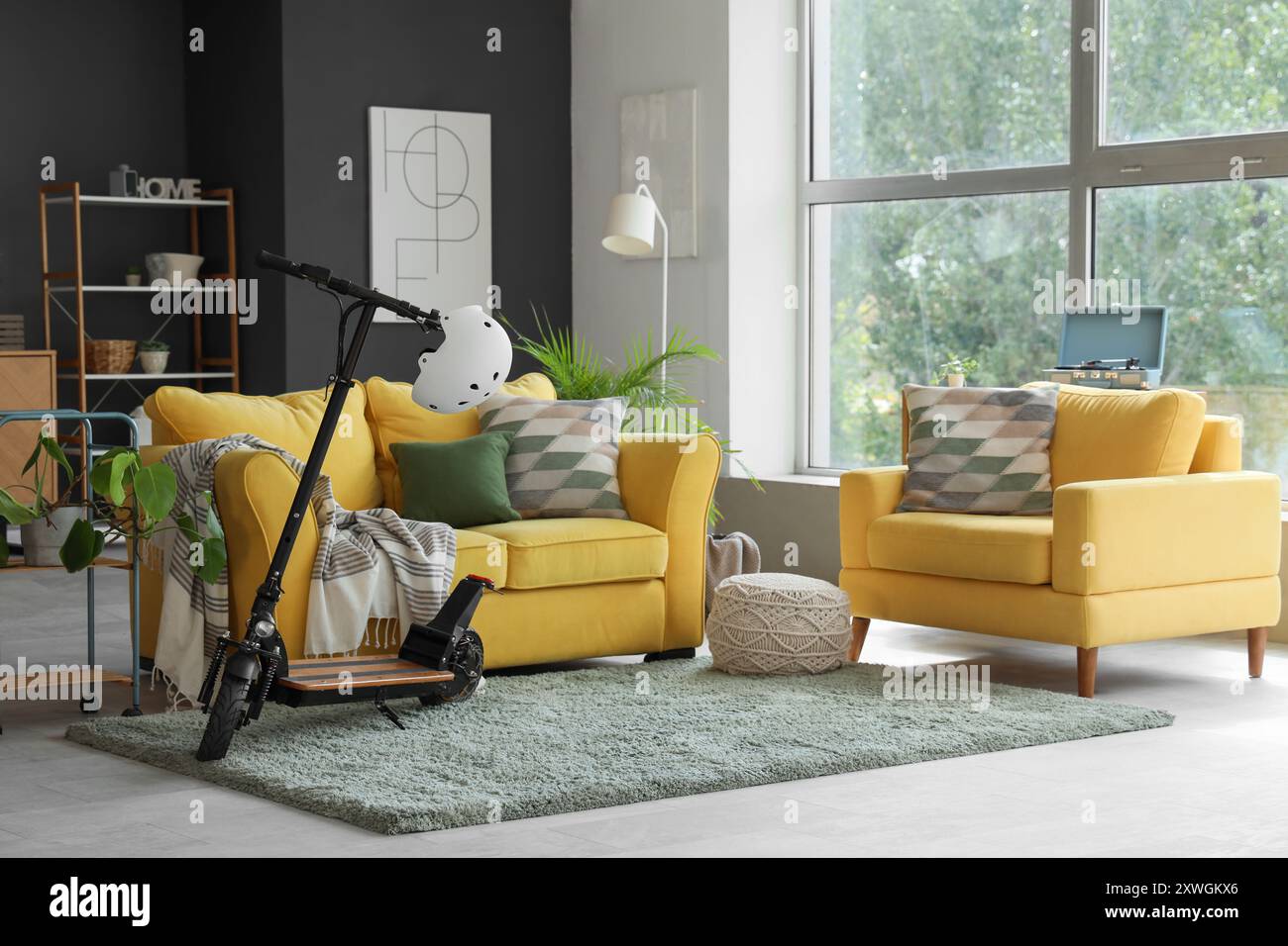Interior of living room with electric scooter, sofa and armchair Stock ...