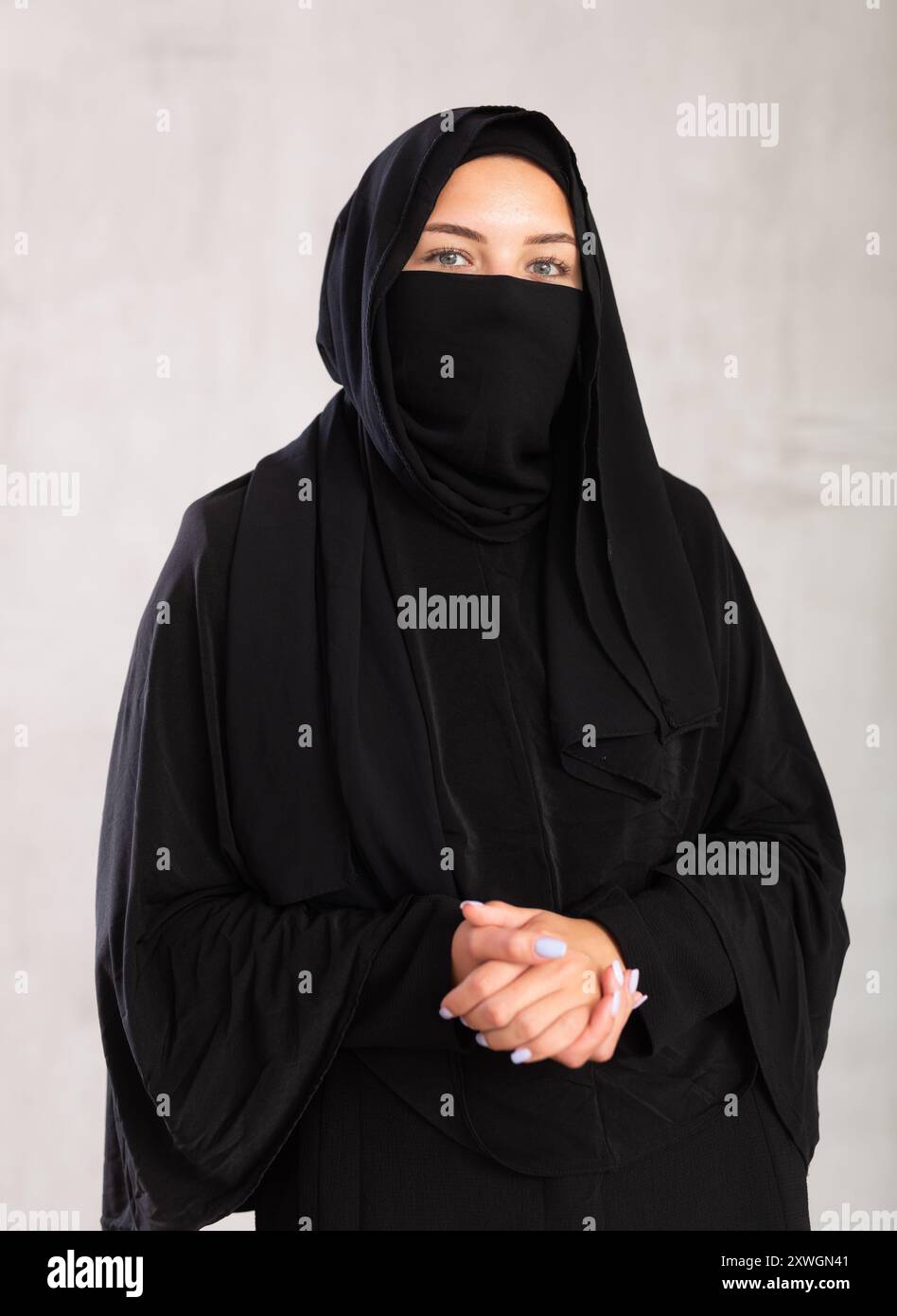 Young woman dressed in traditional islamic clothes with her face ...