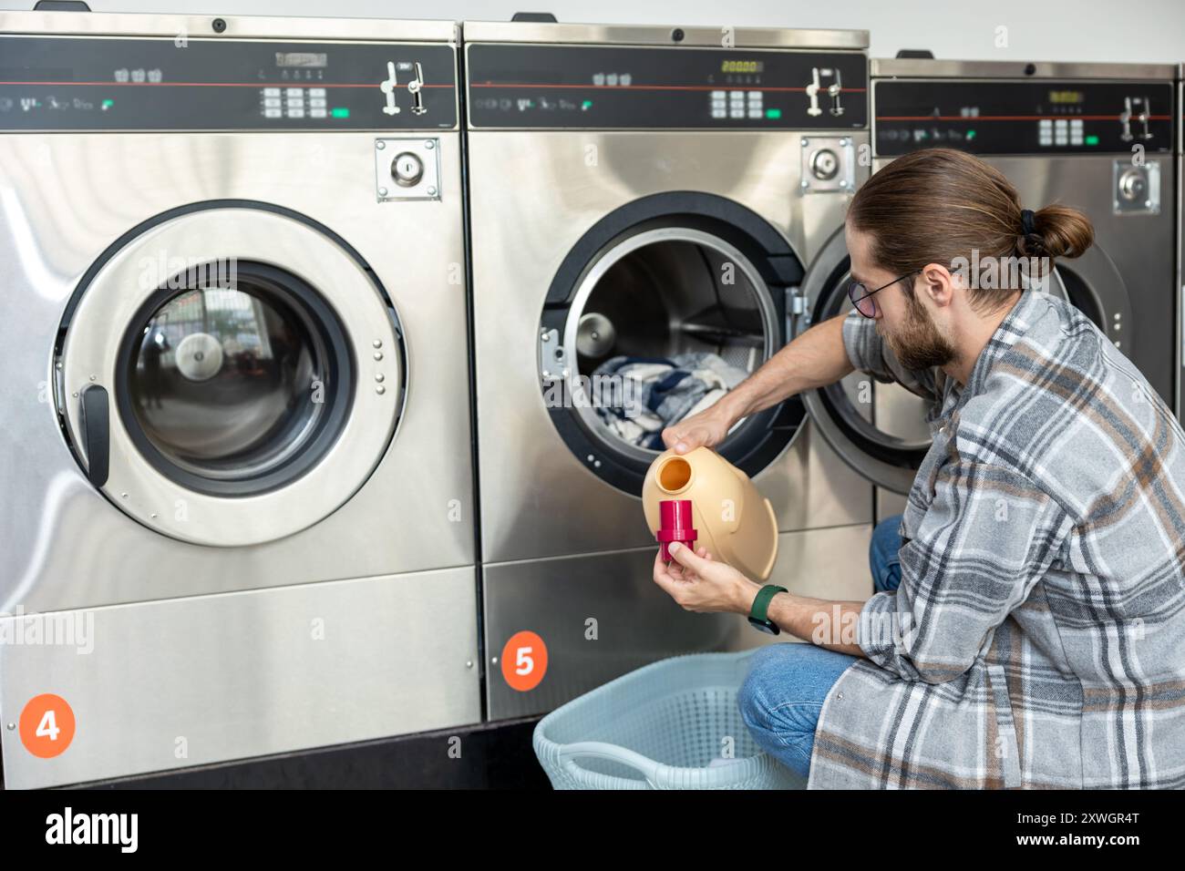 Caucasian adult man managing laundry in public laundry service Stock ...