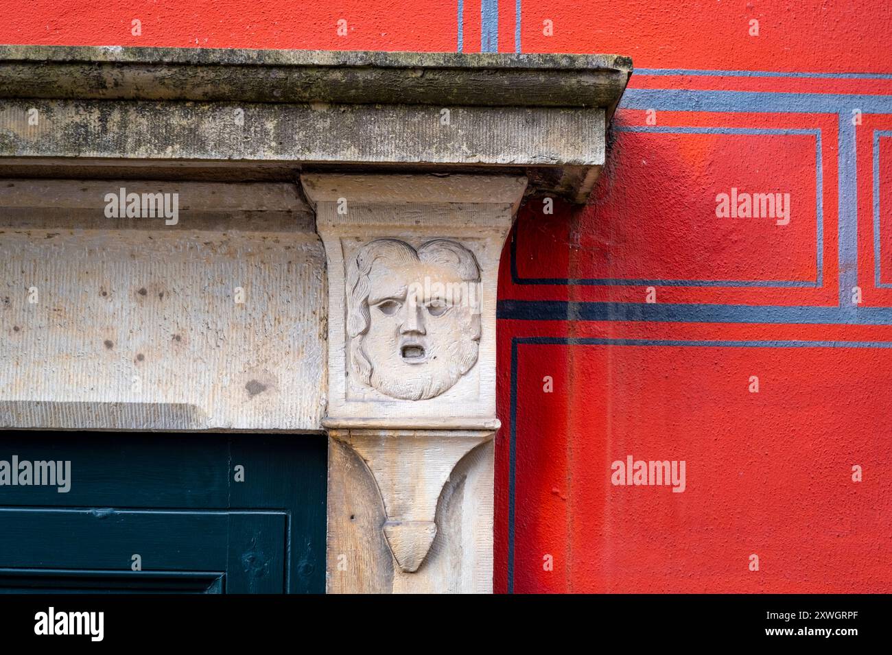 A stone face carved above a doorway at a historic house in Copenhagen ...
