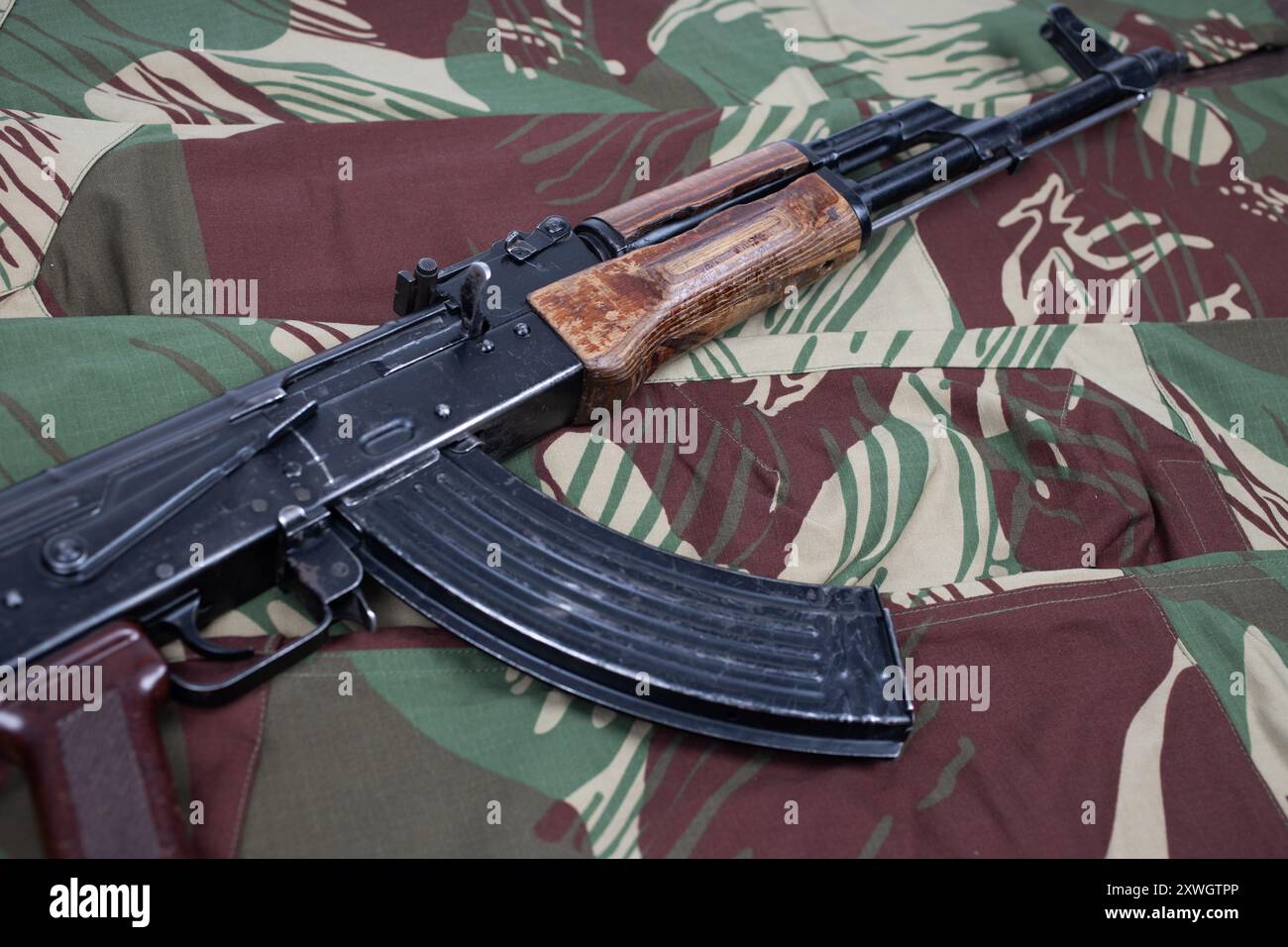 AK assault rifle with cartridges on camo uniform background Stock Photo ...