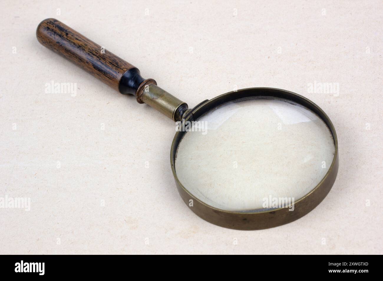 Antique magnifying glass on paper background Stock Photo - Alamy