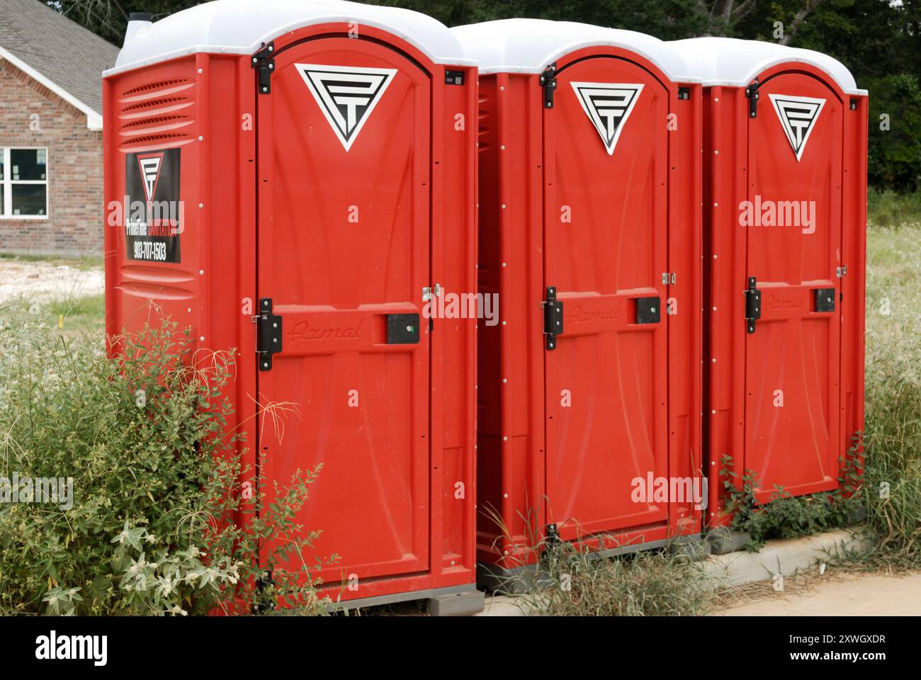 Three portable toilet units side by side on sunny day Stock Photo - Alamy