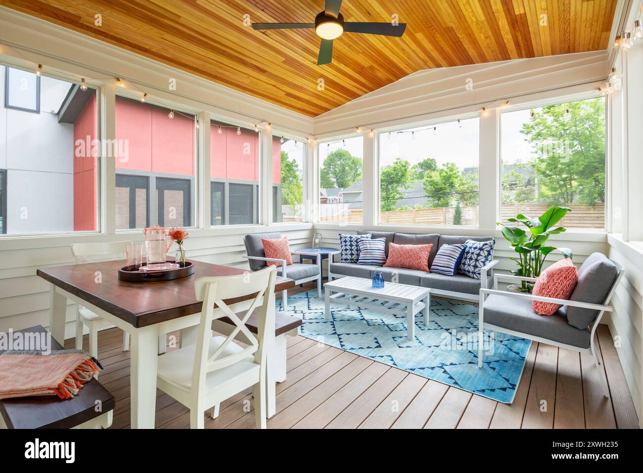 Interior of nice screened porch with sitting area and table and chairs ...