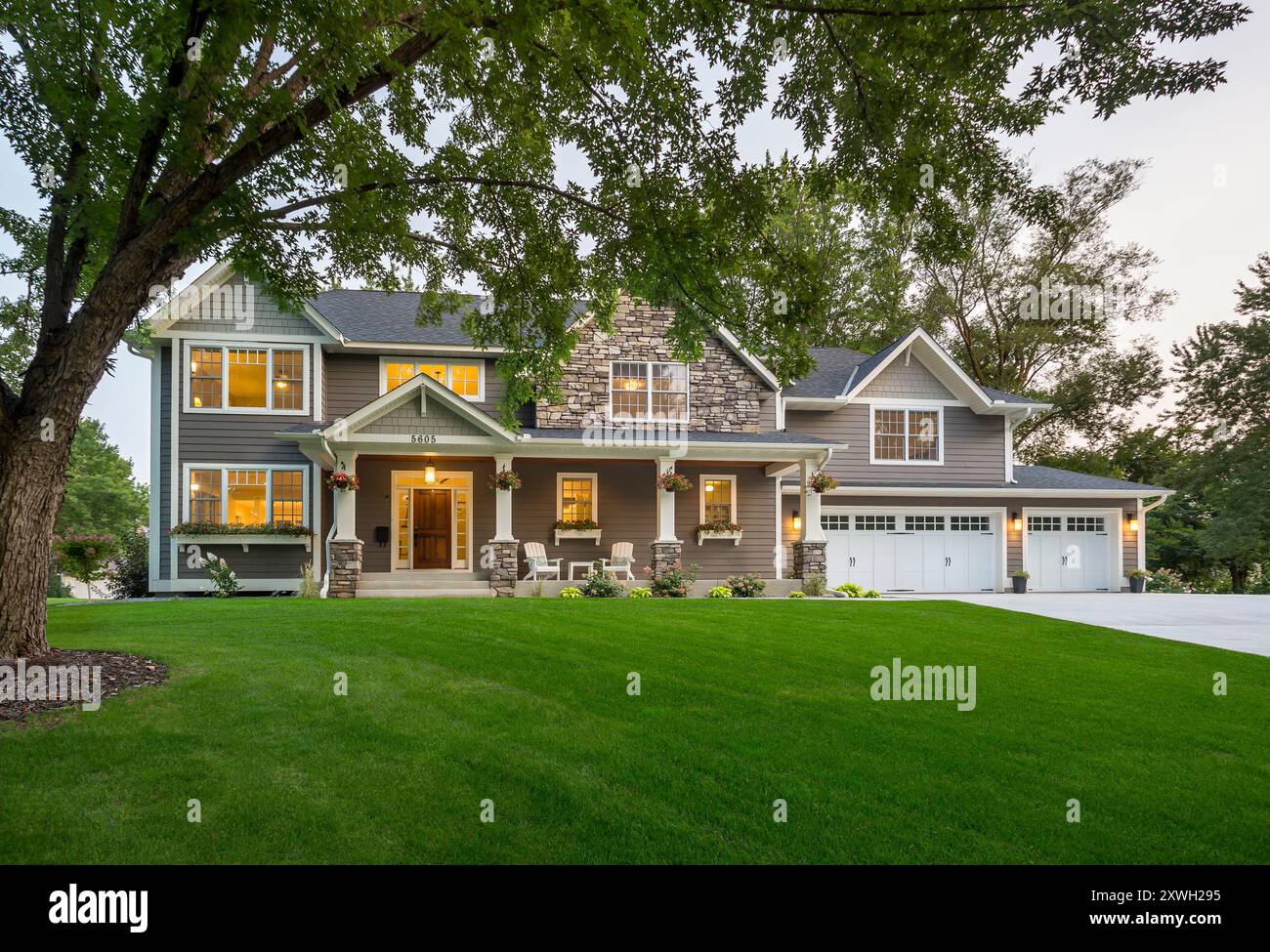 View of front house with large front porch surrounded by trees Stock ...