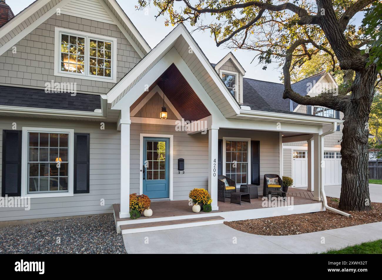 Front exterior of gray house with white trim and black shutters featuring front porch Stock Photo Alamy