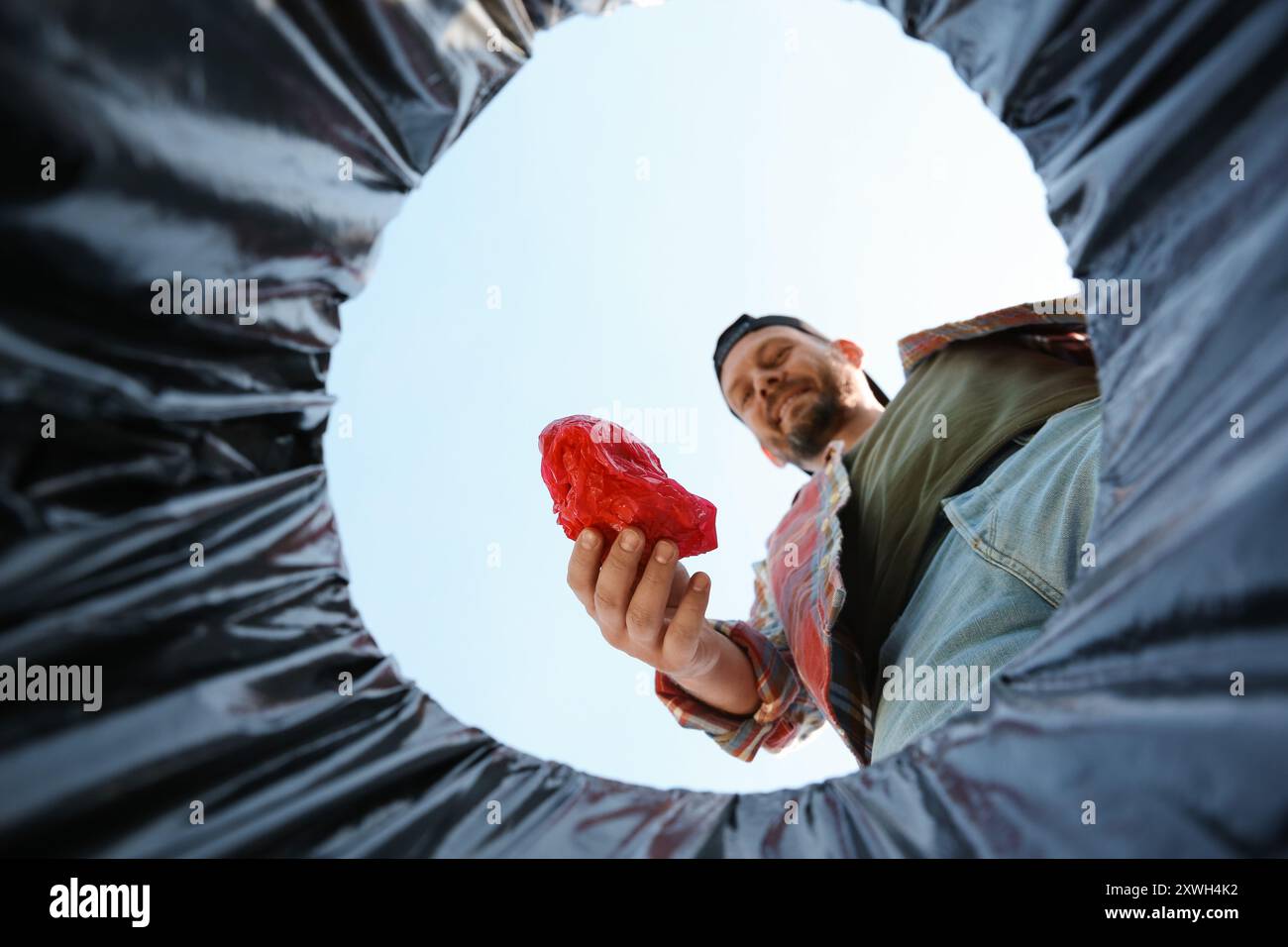 Man throwing garbage into trash bin outdoors, bottom view Stock Photo ...