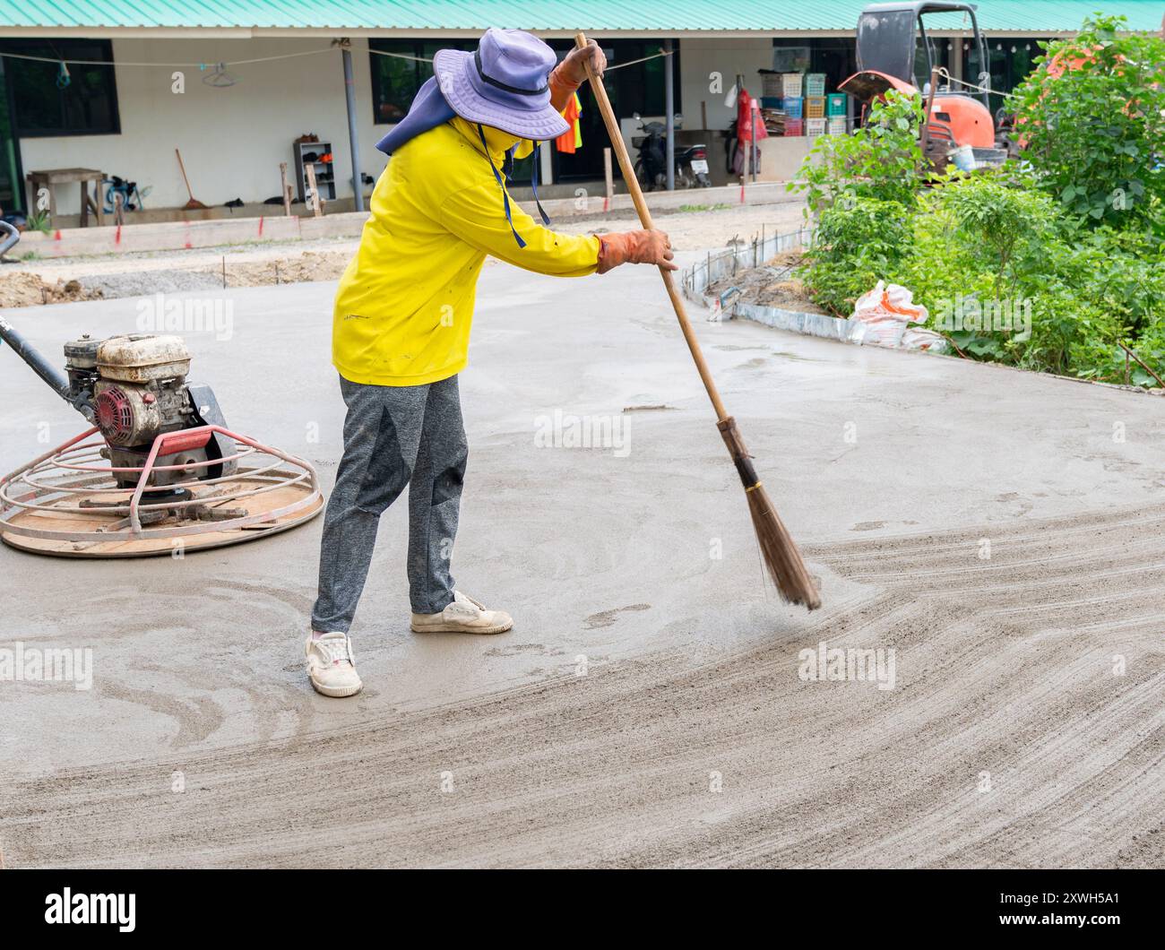 Workers use brooms to make marks to make the concrete road surface in ...