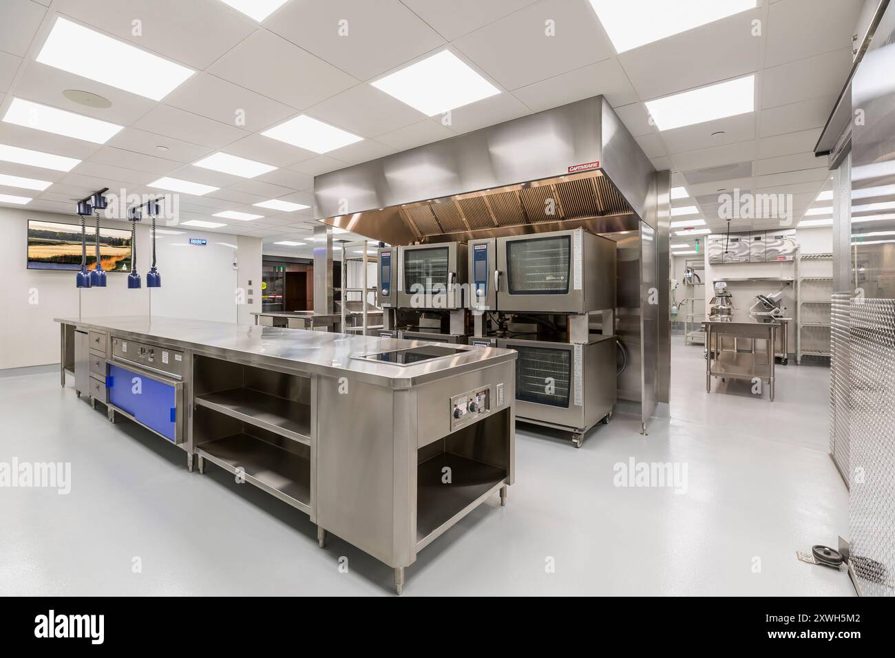 Large commercial kitchen with stainless steel cabinets and shelving ...