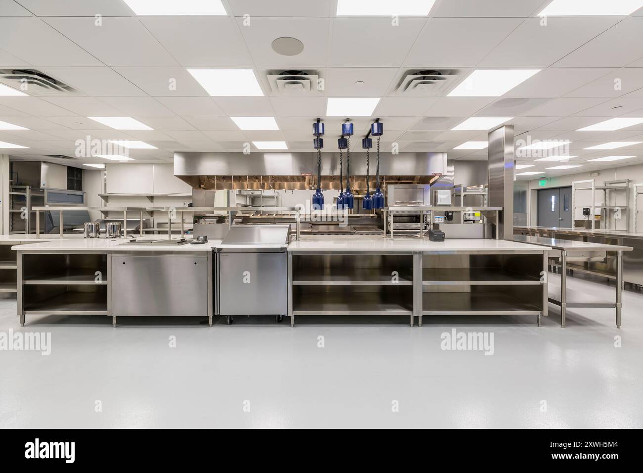 Large commercial kitchen with stainless steel cabinets and shelving ...