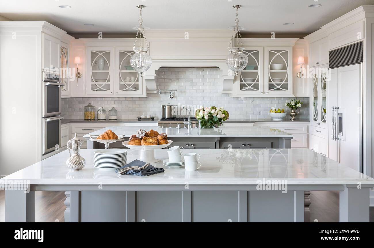 High end white kitchen with two islands and flowers in the sink Stock ...