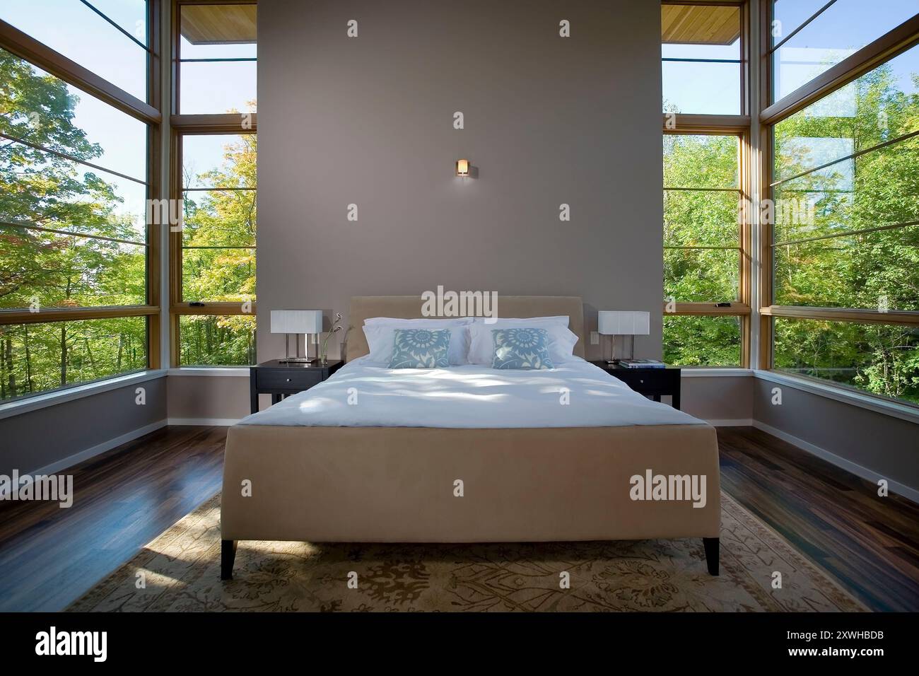 Modern bedroom with large windows on both sides of bed that wrap around ...