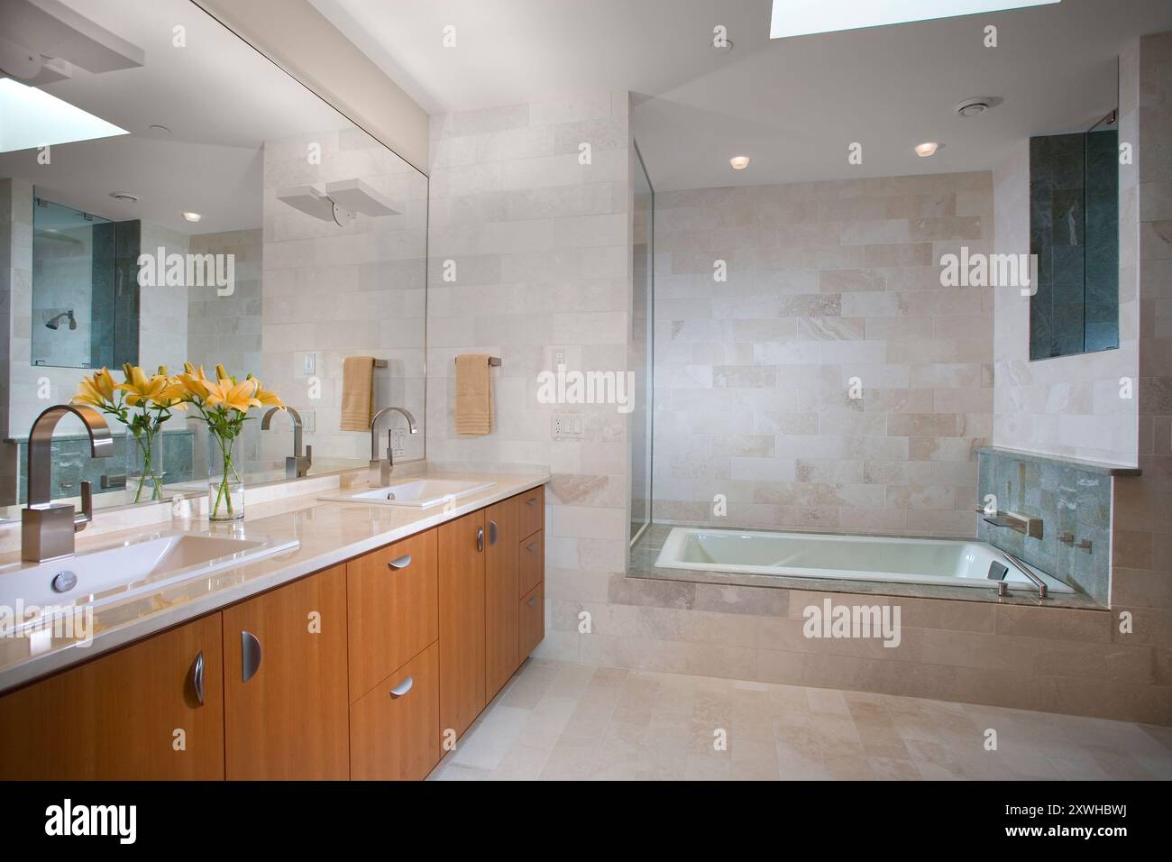 Modern master bathroom with cream colored stone tile and long cherry ...
