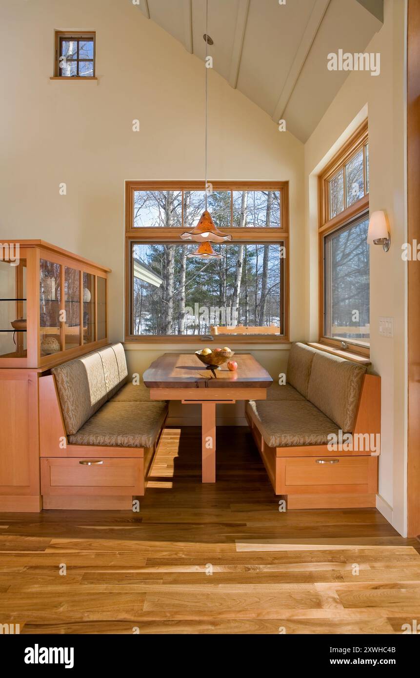 Built-in dining booth in modern cabin with sun streaming in windows ...