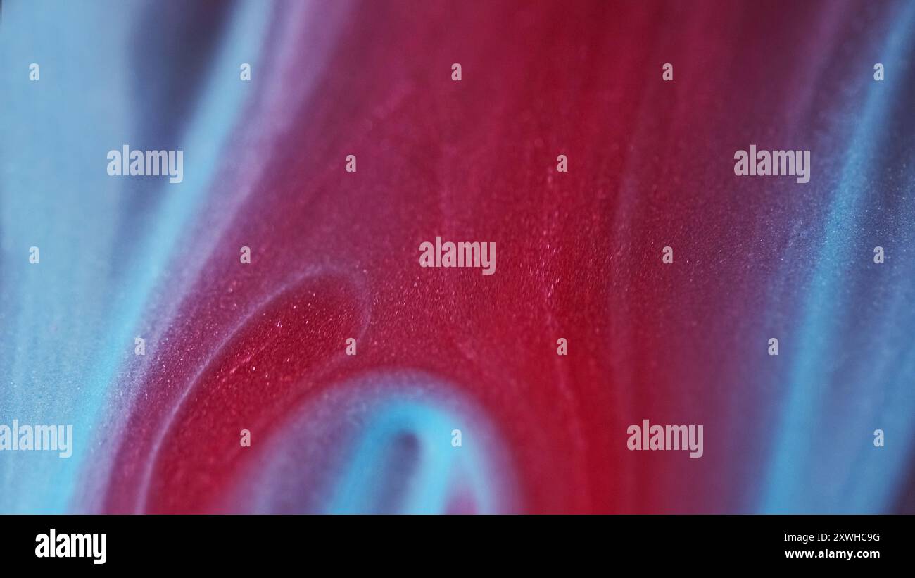 Glitter fluid spill. Bokeh light. Defocused glowing shimmering red blue color wet sand texture ...