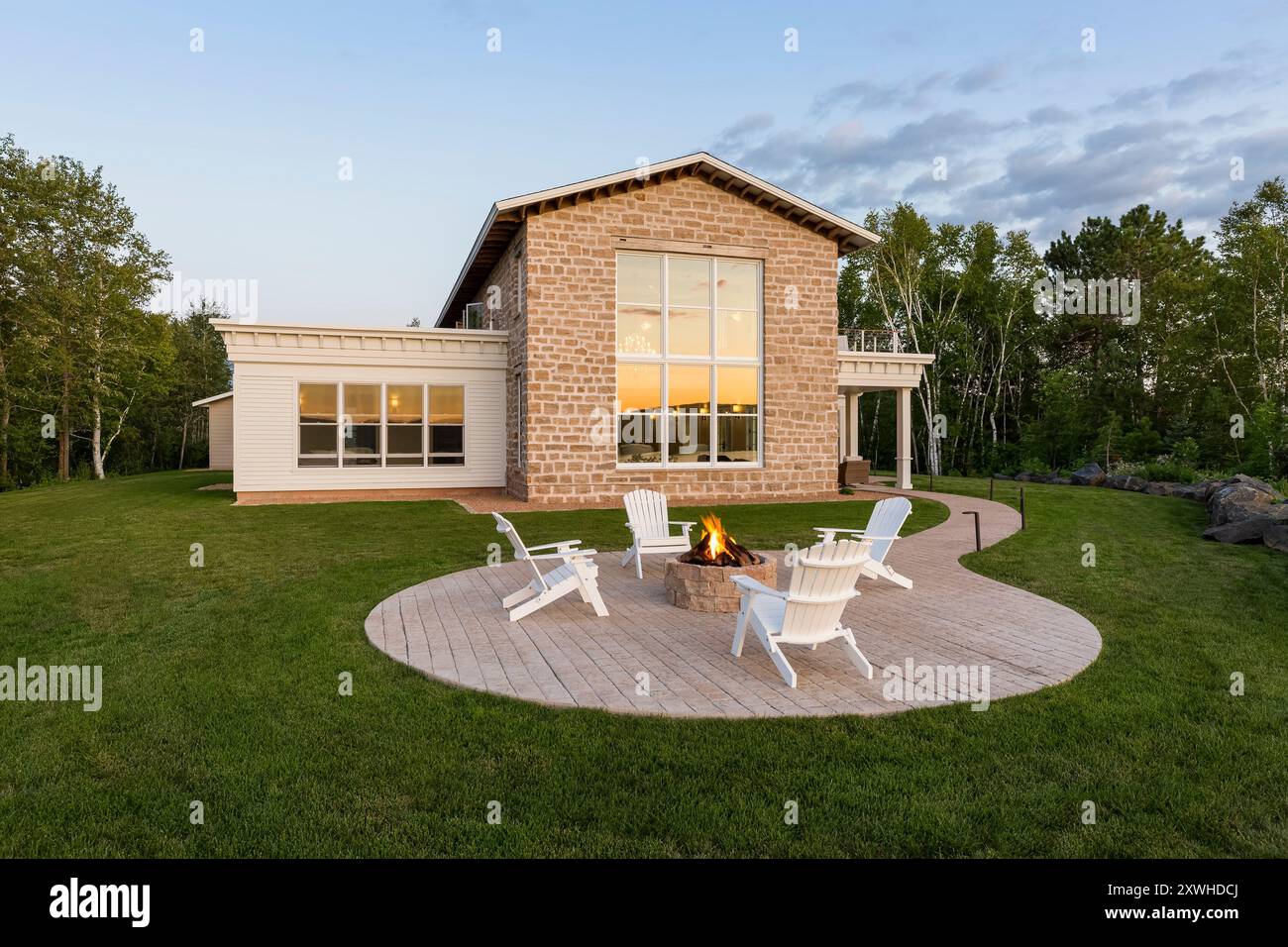 Round curving patio and sidewalk in backyard of new stone house that ...