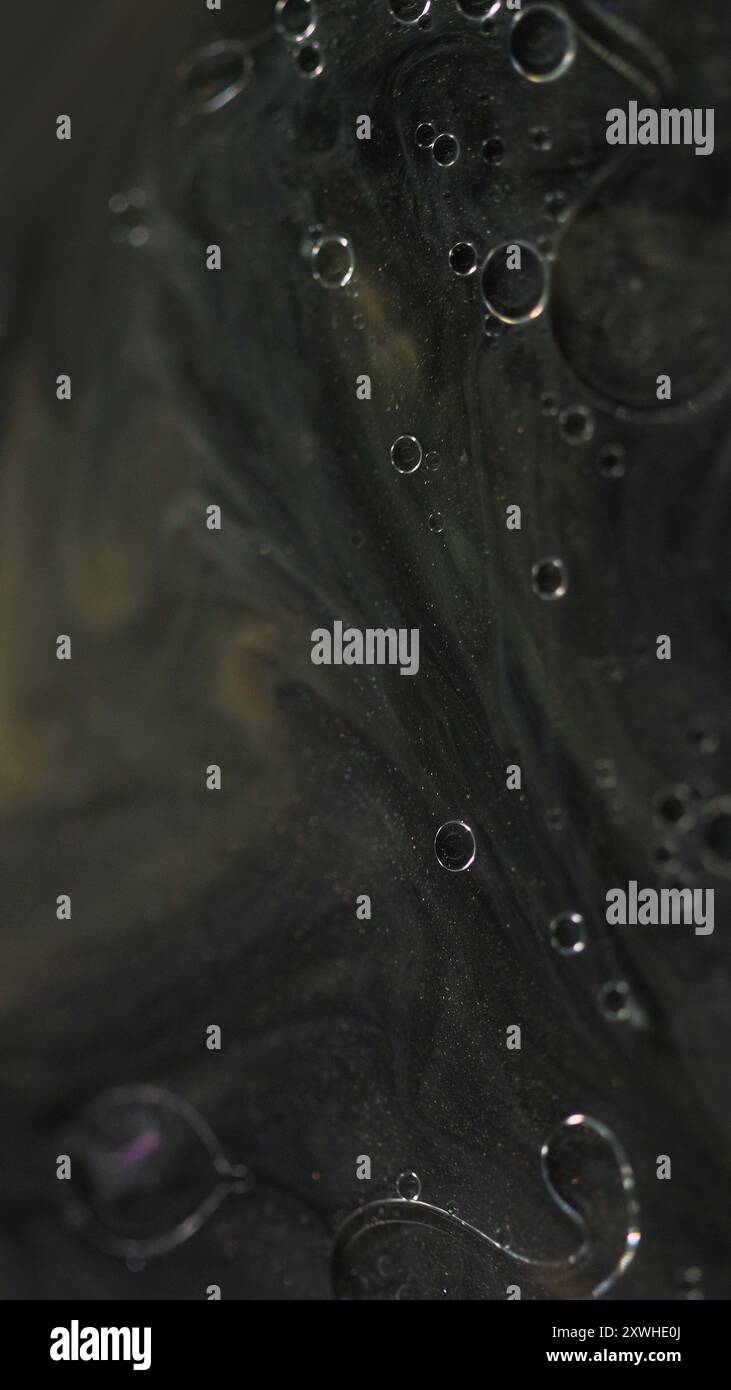 Oil drops paint. Shimmer ink. Defocused black golden color floating ...
