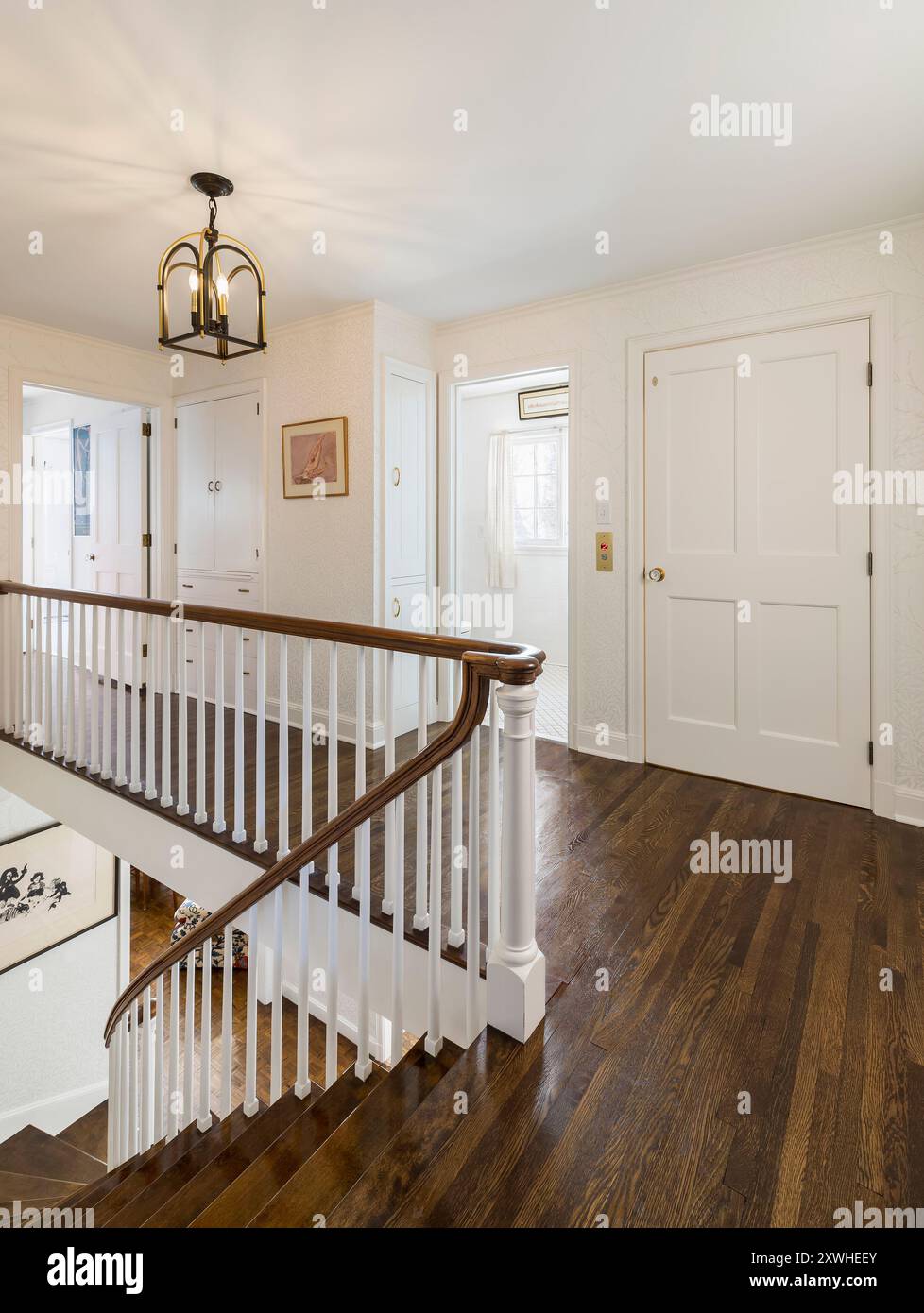 Second floor landing of house showing stairs and railing and door to ...