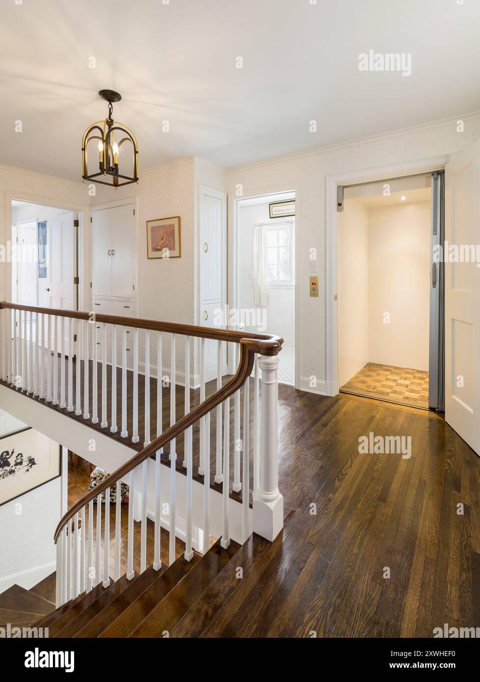 Second floor landing of house showing stairs and railing and door open ...
