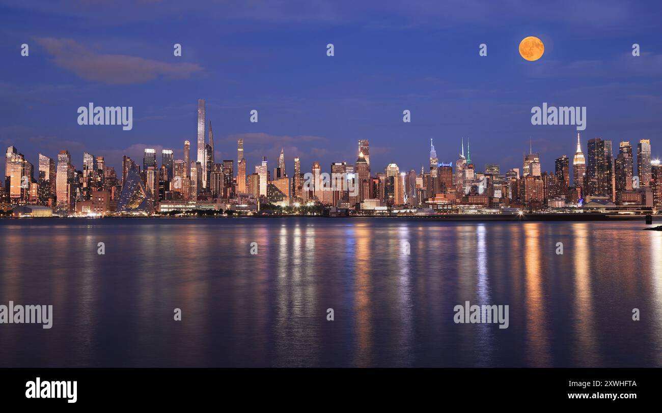 New York City skyline illuminated at dusk with orange full moon, view ...