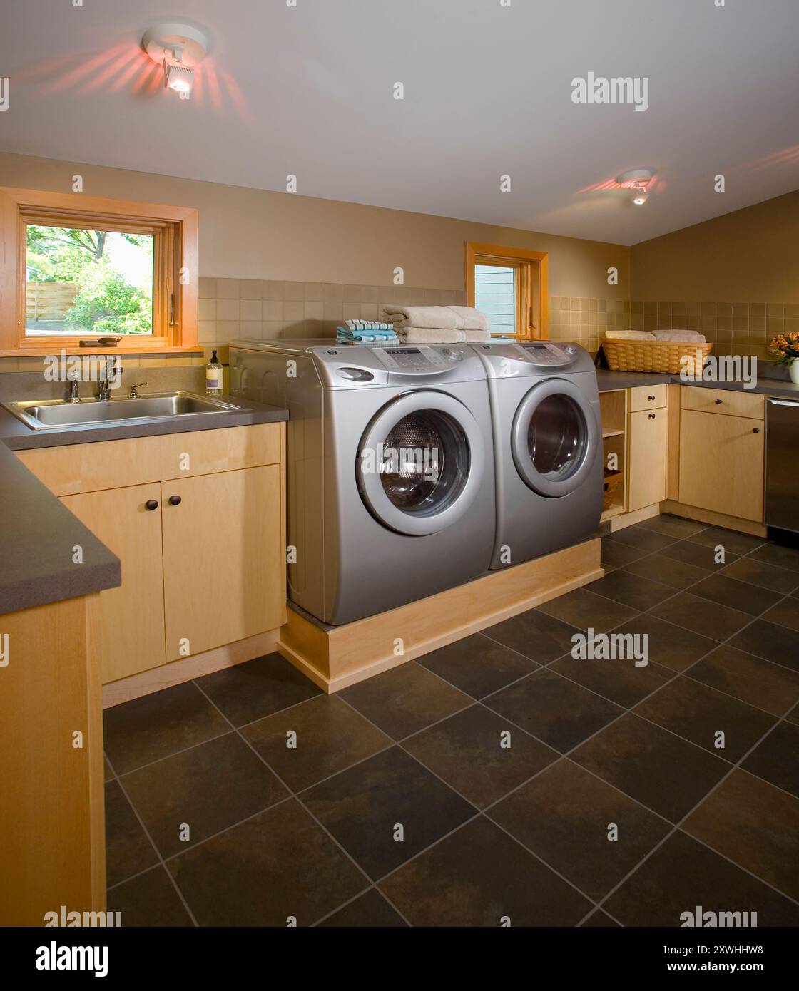 Laundry room with front load washer and dryer on platform Stock Photo ...
