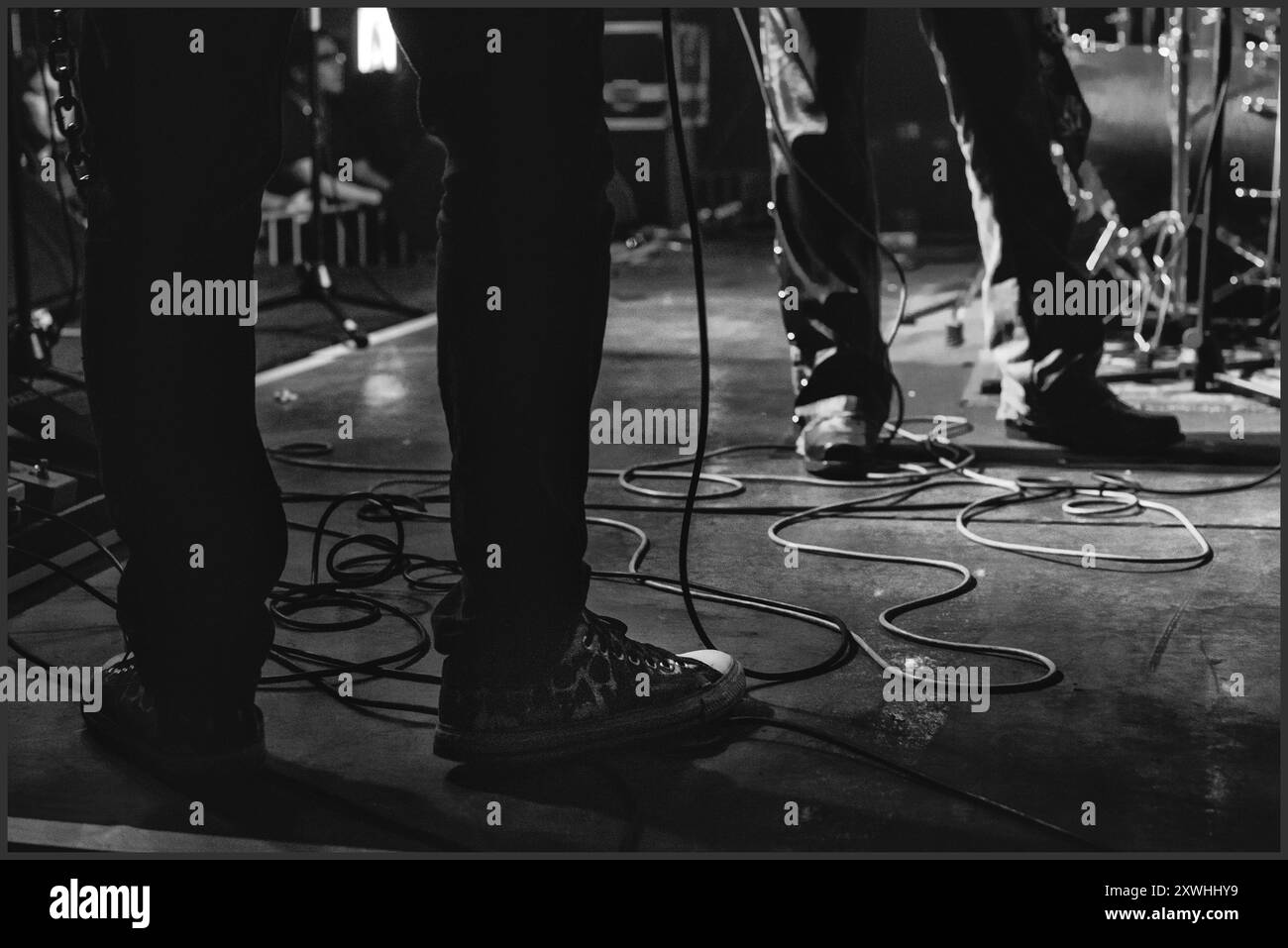 Black and white photo of rock band musicians standing on stage with ...