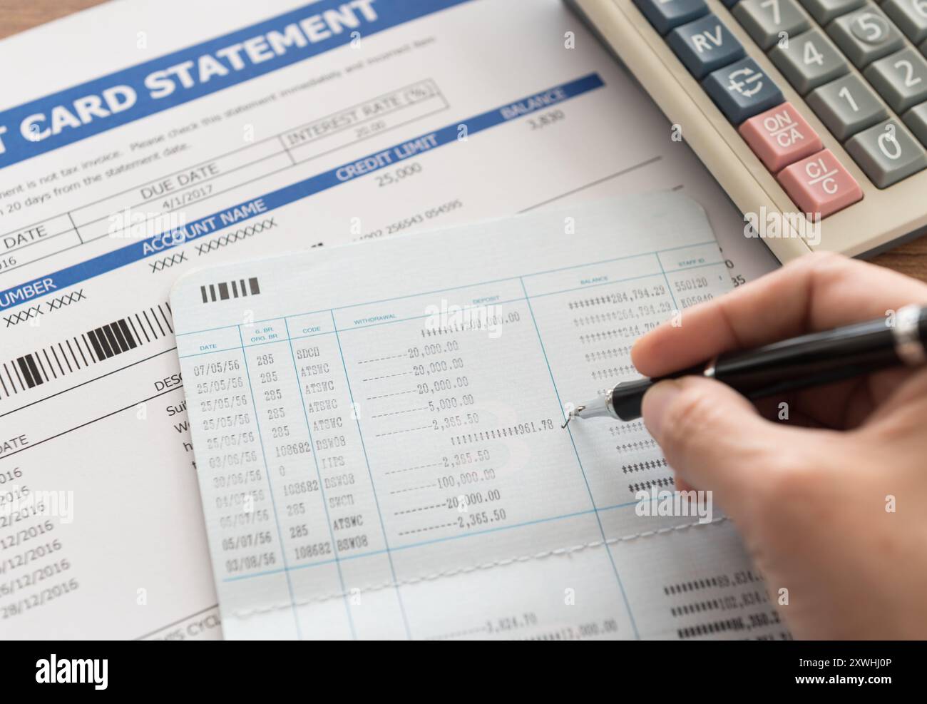 women checking amount in bank account passbook with bank statement ...