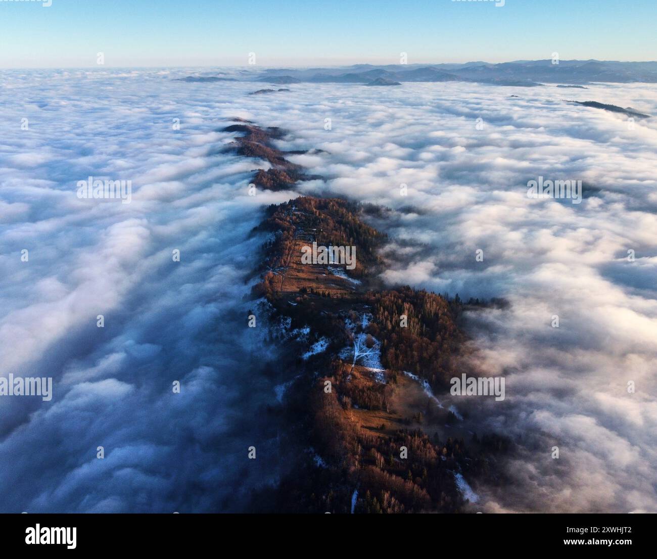 Breathtaking aerial view of mountain ridge piercing through sea of ...