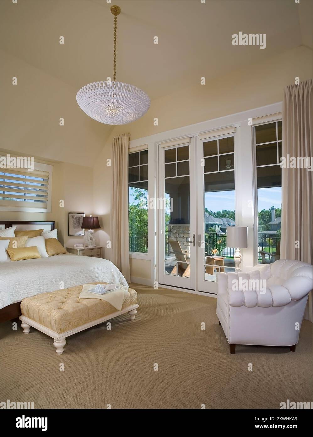 Bedroom with double doors leading to large outdoor deck with shades ...