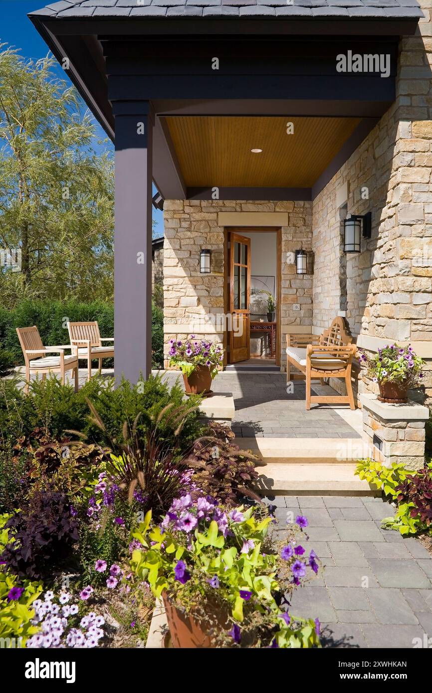 Front porch and entrance to high end home with many flowers and stone ...