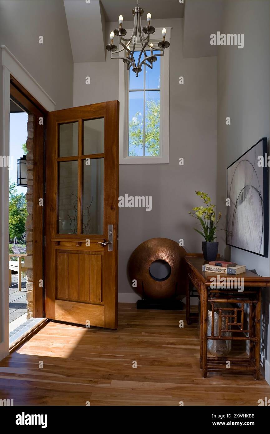 Front hallway of home with table and artwork and door open Stock Photo ...