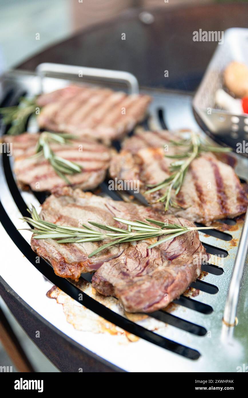 A beef steak from marbled beef seasoned with sprigs of rosemary is ...