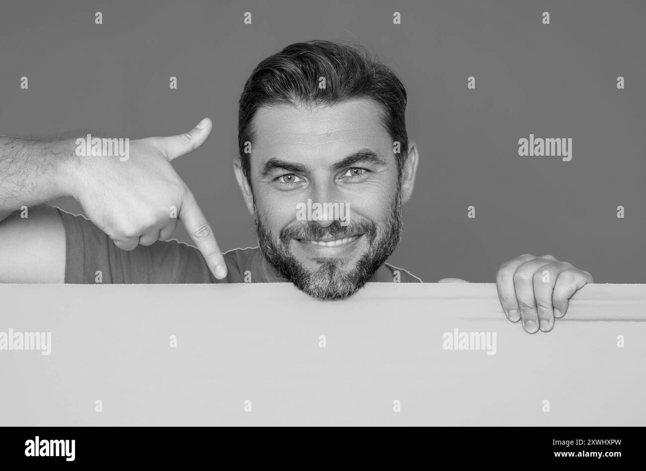 Guy with blank banner ad, isolated on studio background. Man holding ...