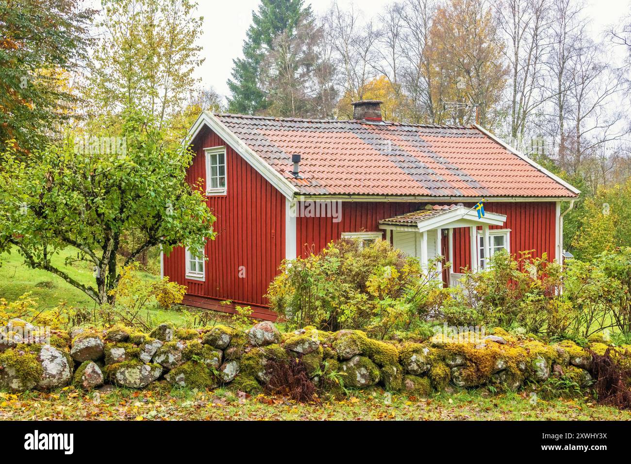 Red idyllic wooden croft with a mossy stone wall Stock Photo - Alamy