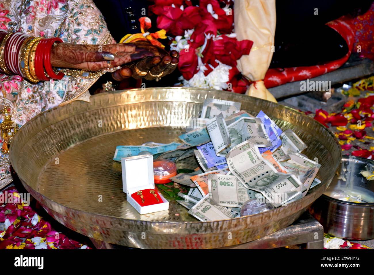 The bride and groom and the plate full of money during a Hindu wedding ...