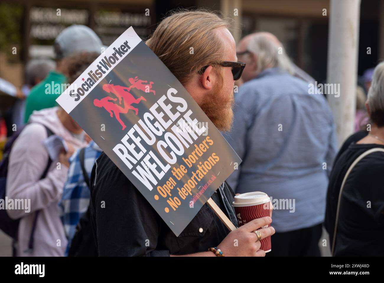 Man holding a refugees welcome sign at an anti far right support rally ...