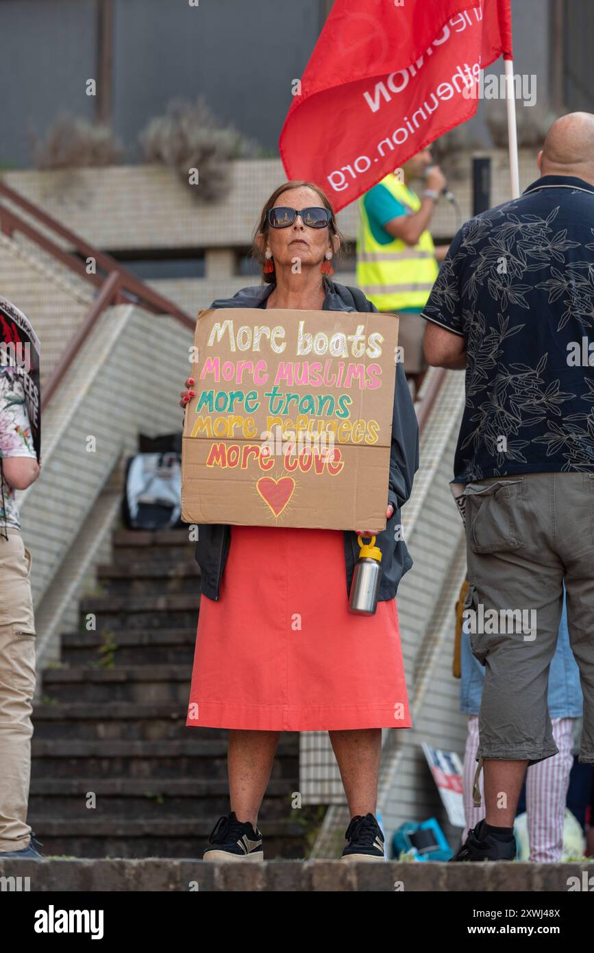 Woman holding a home made sign promoting more love at an anti racism ...