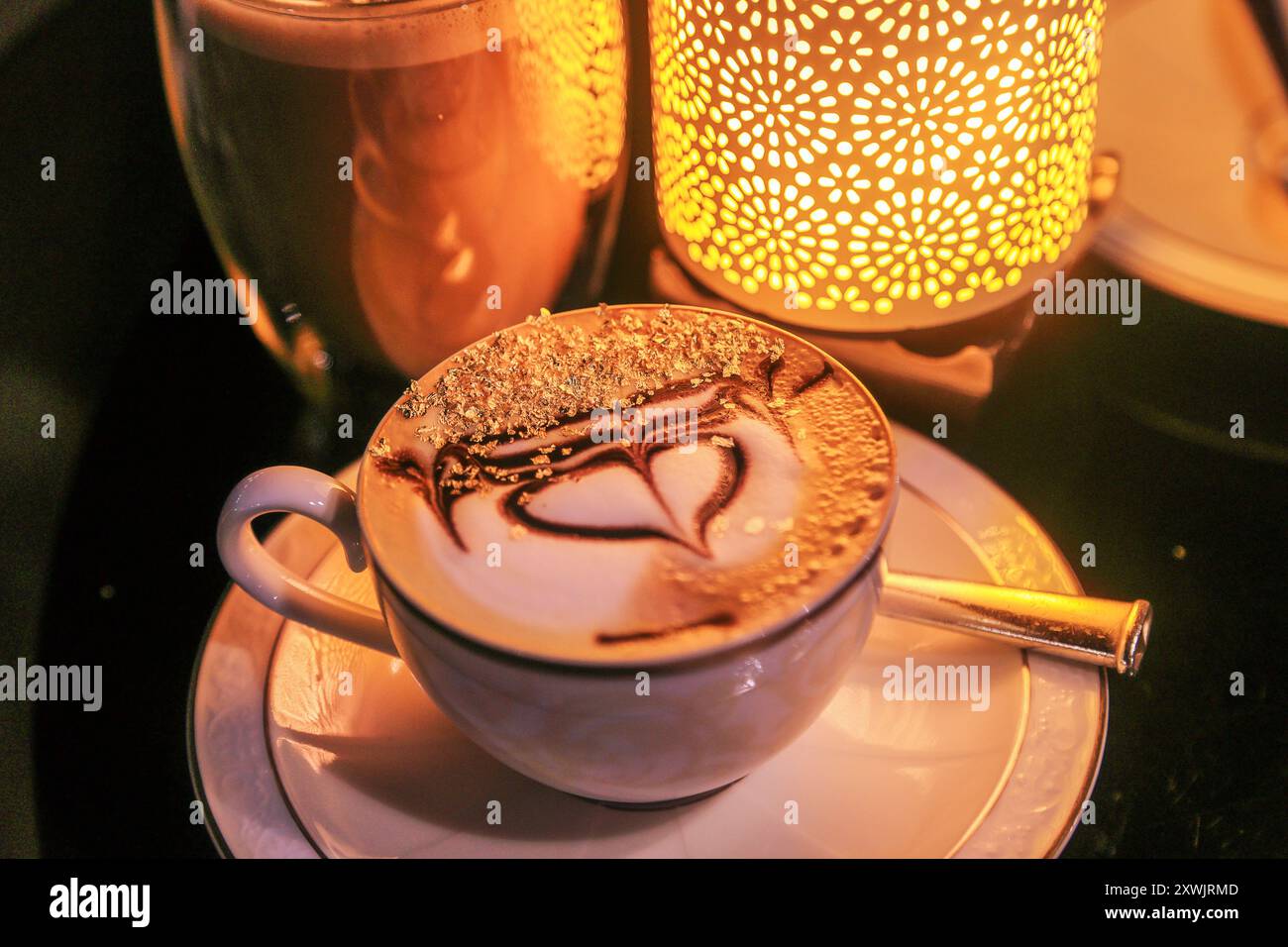 Coffee with gold flake decoration with candle light in arabic style ...