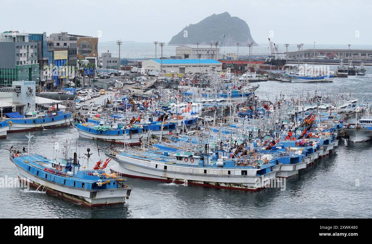 Fishing boats are anchored at a port as Typhoon Jongdari approaches ...
