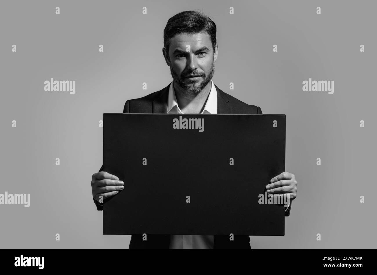 Serious business man holding empty board. Successful businessman ...